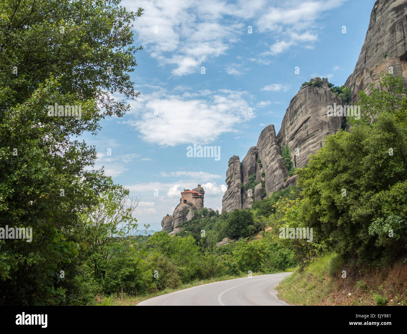 Meteora road below the rocks with Moni Agiou Nikolaou monastery in the ...