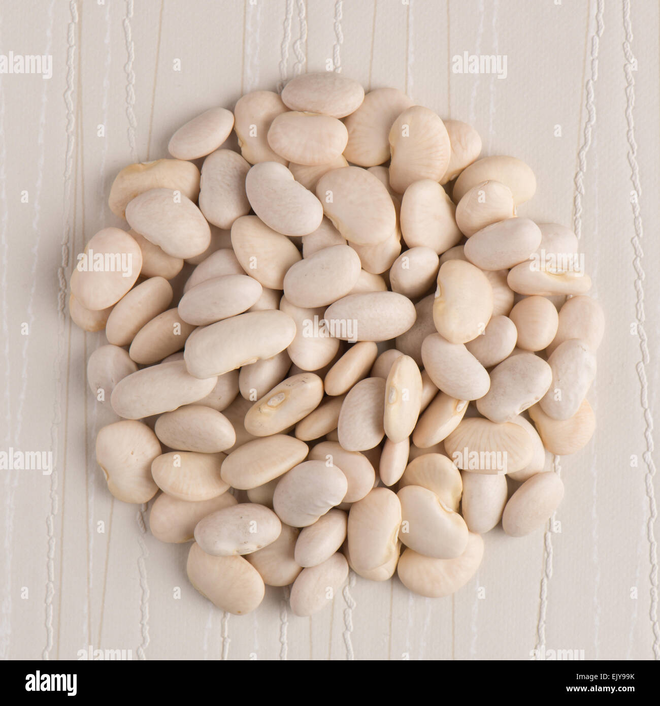 Top view of circle of white beans against beige vinyl background Stock ...