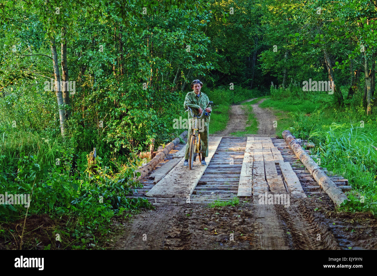 Rural road before village. Wooden bridge over small river Stock Photo ...