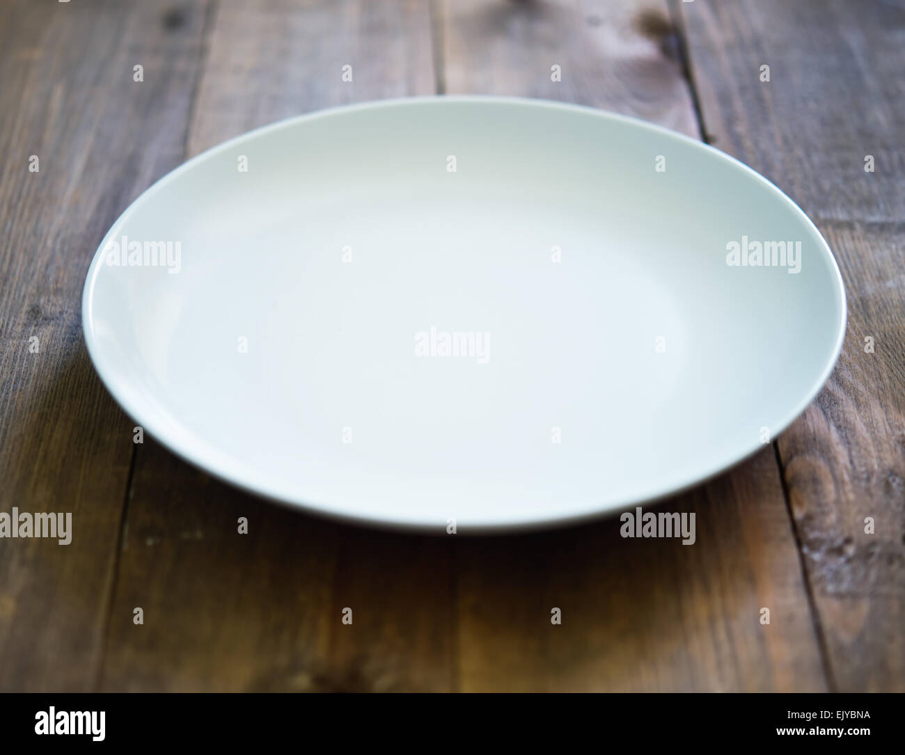 empty plate on a wooden table Stock Photo - Alamy