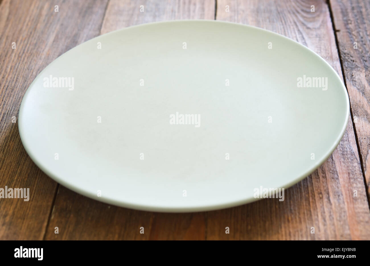 empty plate on wooden table Stock Photo - Alamy