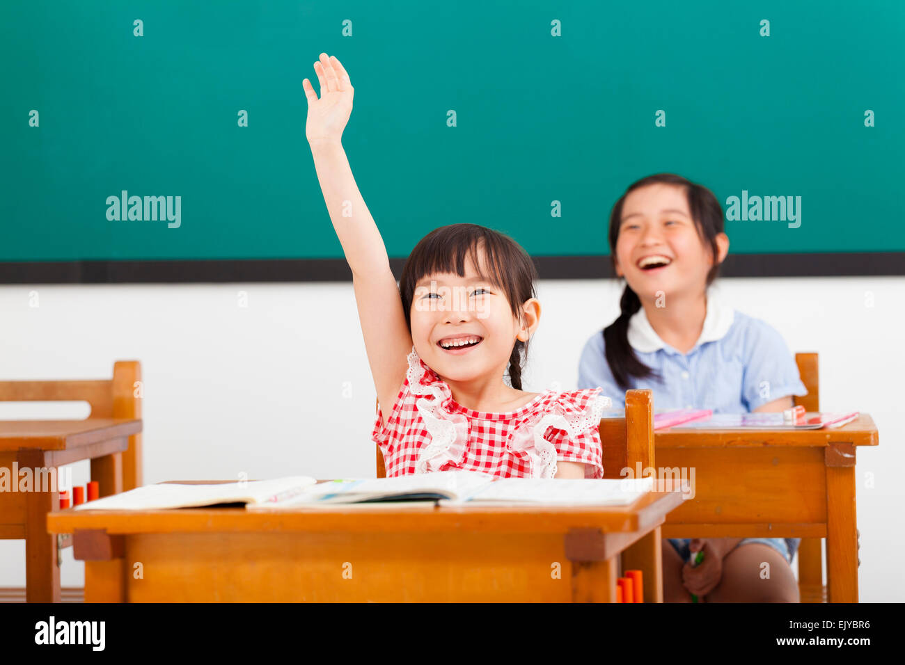 happy school children raised hands in class Stock Photo - Alamy