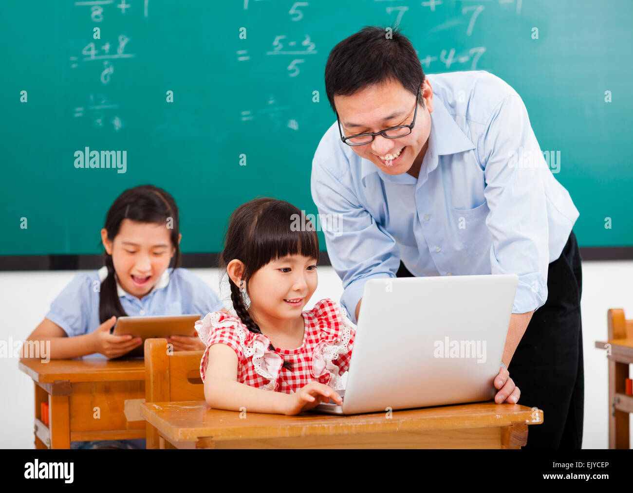 teacher teaching the computer with children in classroom Stock Photo ...