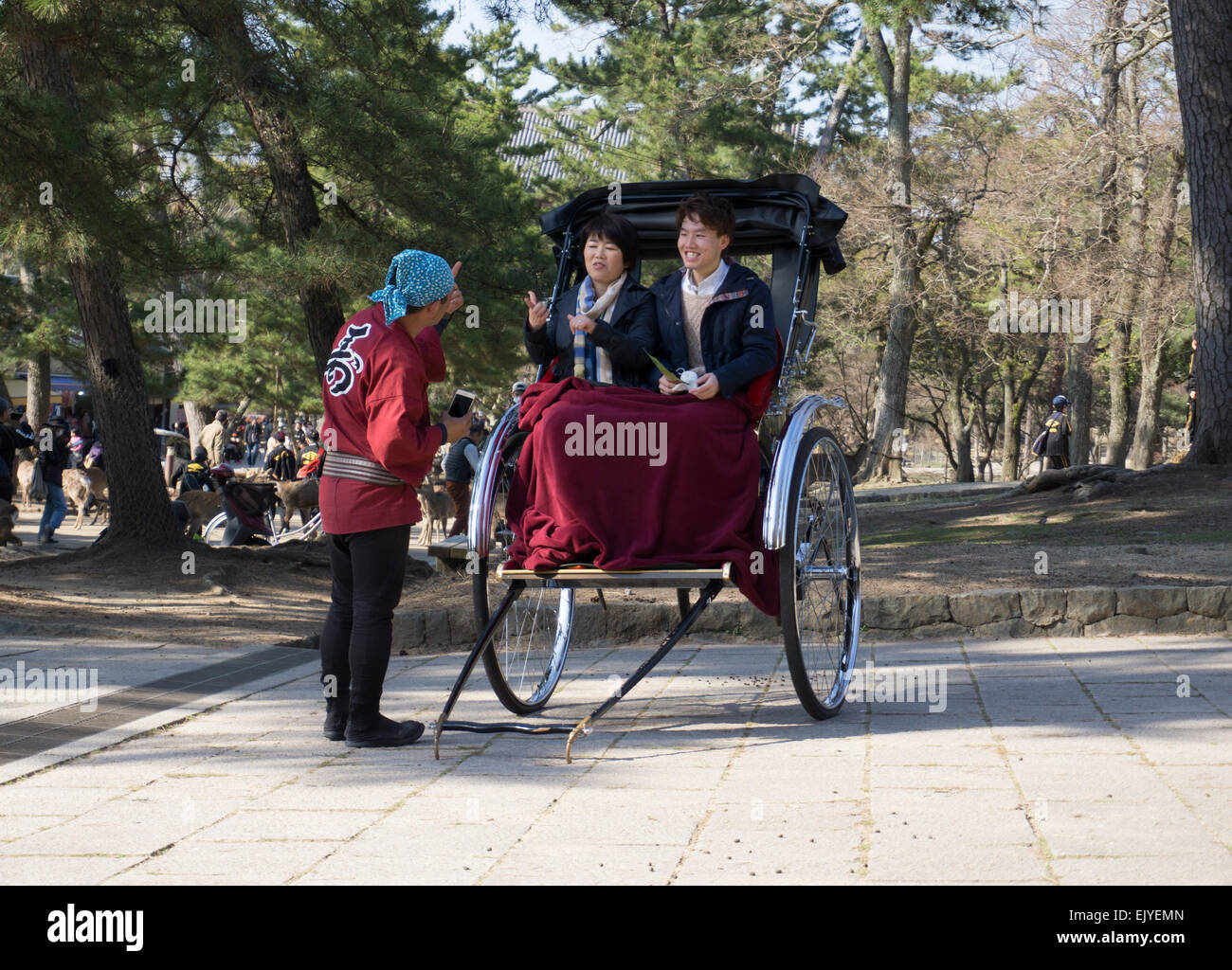 Local rickshaw runner pulling two tourists in a traditional Japanese ...