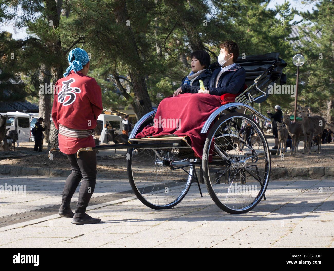 Local rickshaw runner pulling two tourists in a traditional Japanese ...