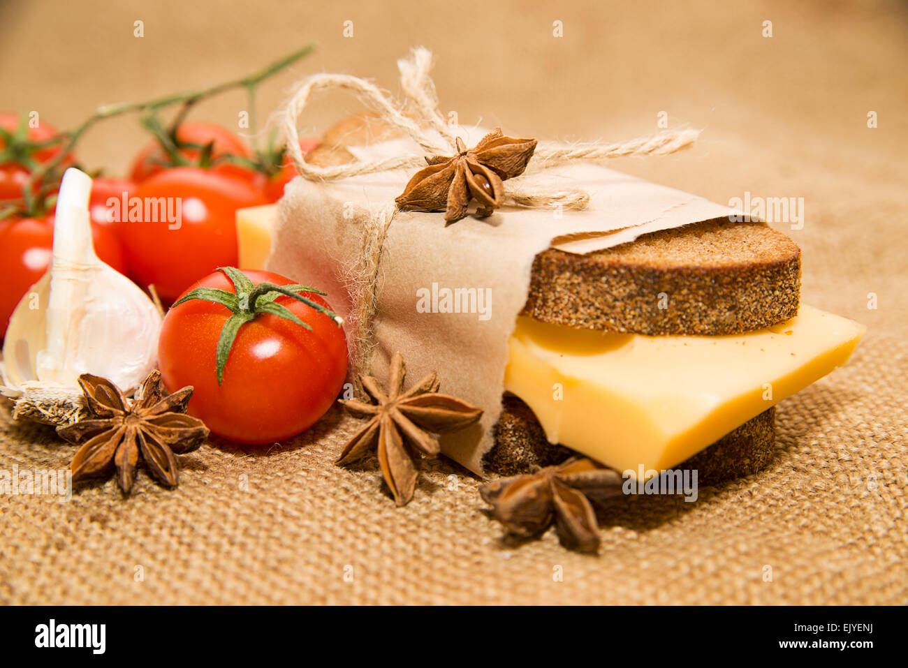 Sandwich with cheese wrapped in paper, cherry tomatoes and garlic on ...