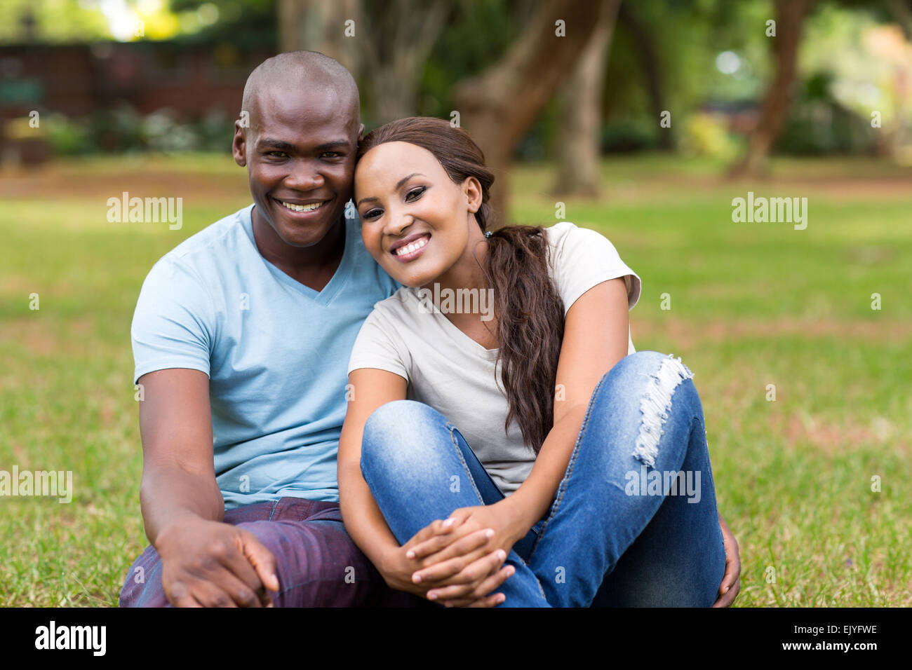 cute African American couple sitting on grass in the park Stock Photo ...