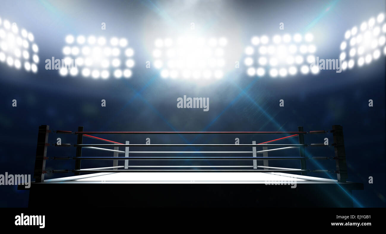 An boxing ring surrounded by ropes spotlit by floodlights in an arena ...