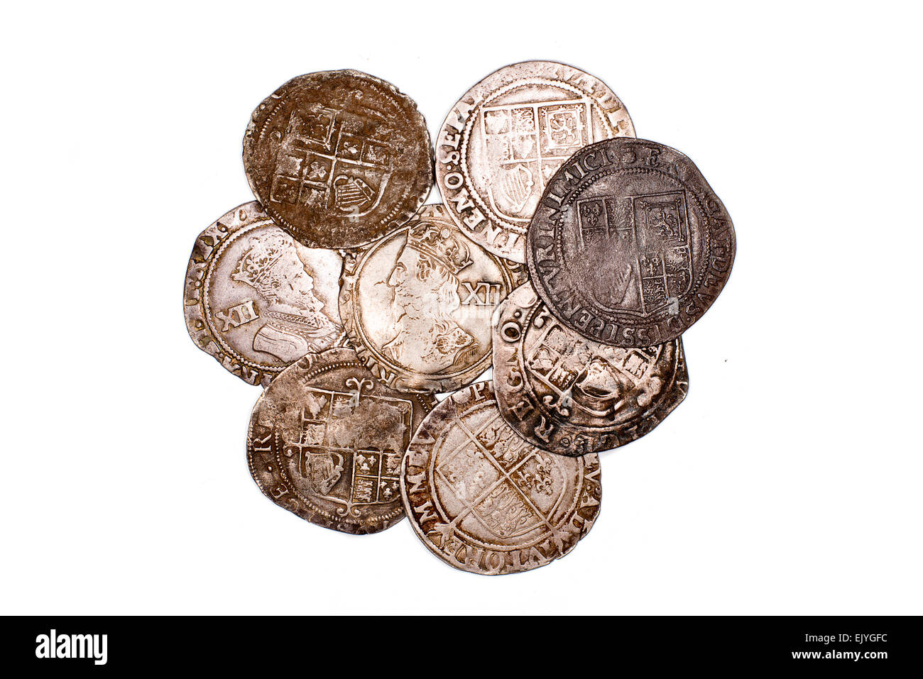 A lot of old silver coins with portraits of kings on a white background ...