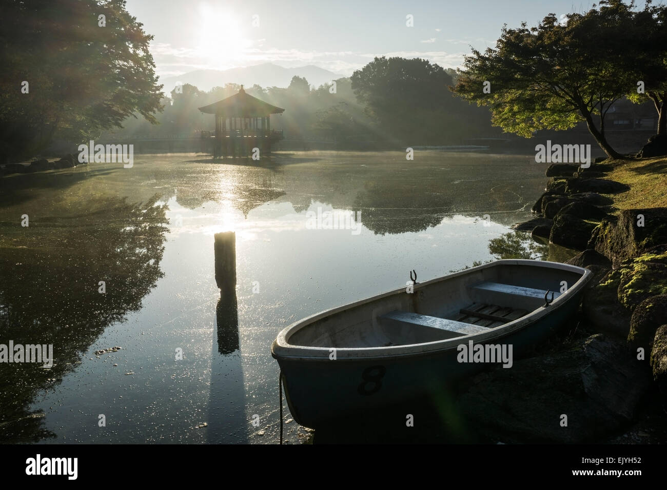 Ukimido Pavilion reflected in a pond at dawn in Nara, Japan. Rowing ...