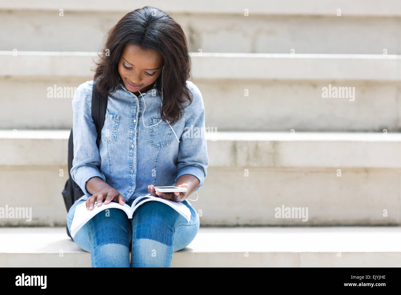pretty African American college student reading a book Stock Photo - Alamy