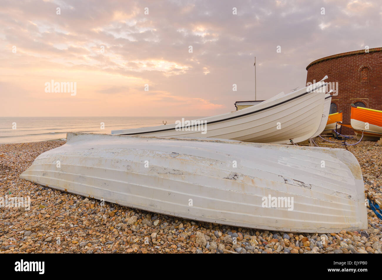 Rowing boats on a beach around sunset Stock Photo - Alamy