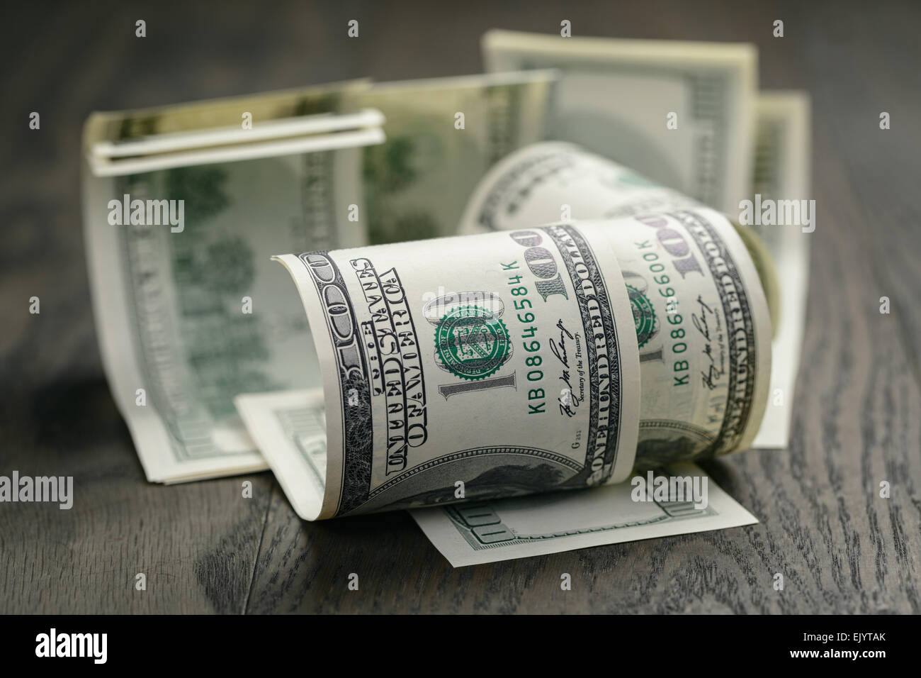hundred dollar bills on wood table Stock Photo - Alamy