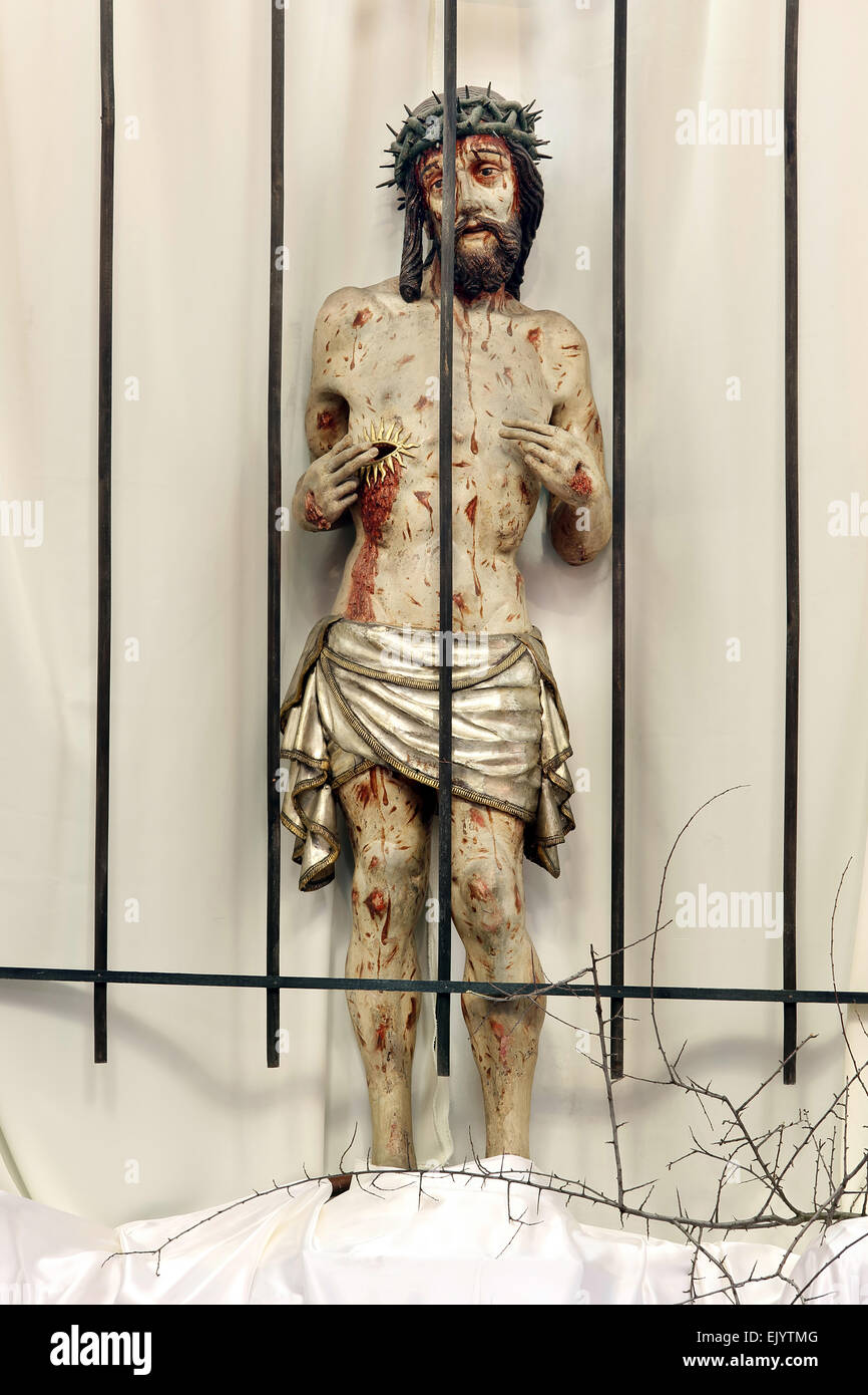 Jesus behind bars in prison. Wooden figure of Jesus in the church ...