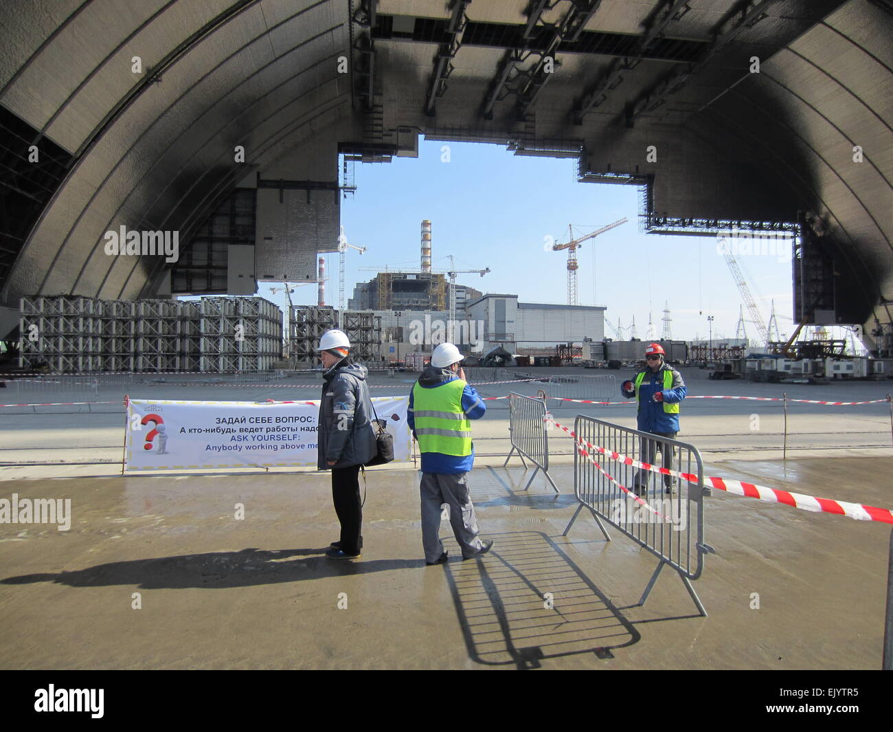 Workers stand under the new protective covering for the Chernobyl ...