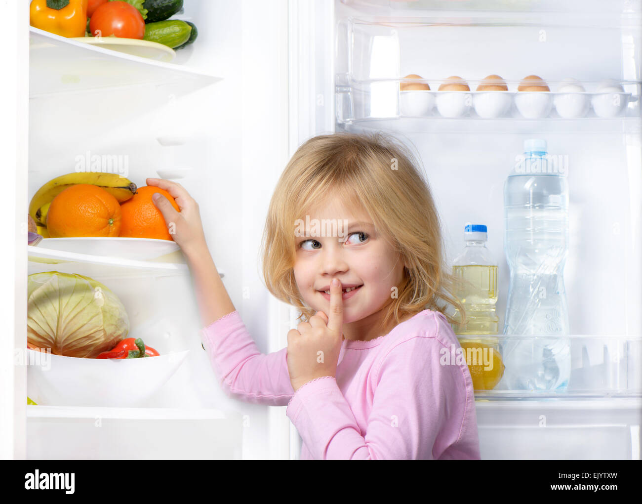 Little cute girl making silence sign near open fridge Stock Photo - Alamy