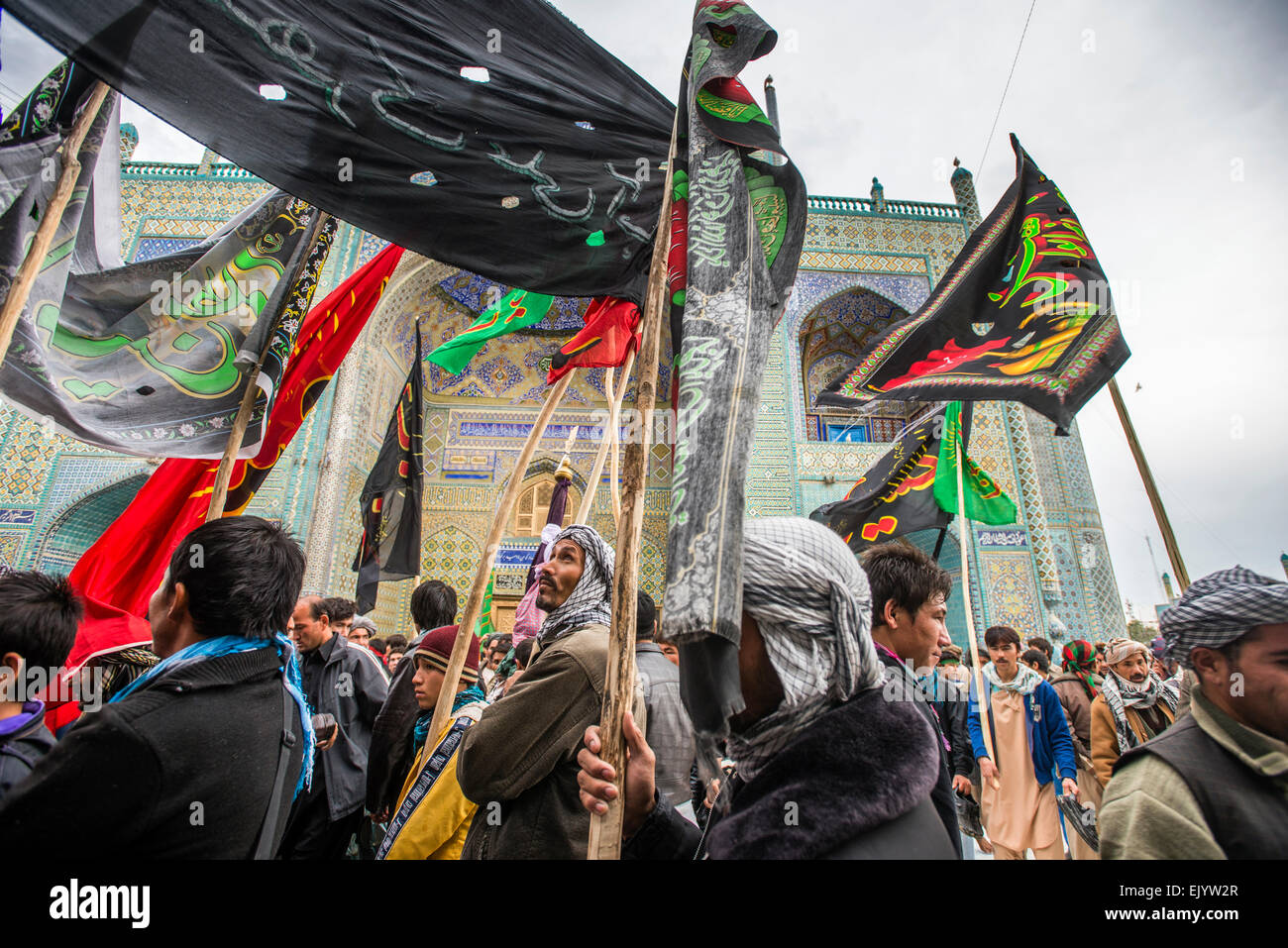 People carry festive flag in the yard of Shrine of Ali on Day of Ashura ...