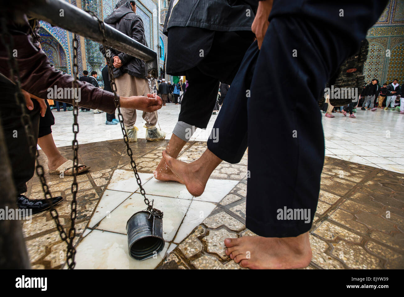 Muslims wash their legs before prayer in the yard of the Shrine of Ali ...