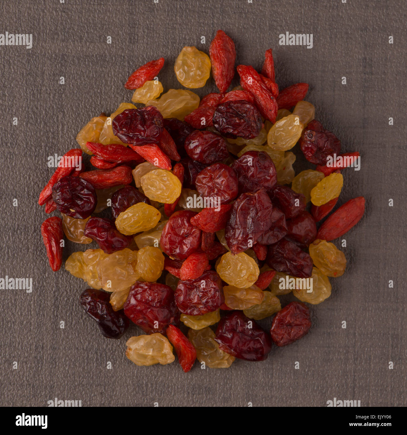 Top view of circle of mixed dried fruits against brown vinyl background ...