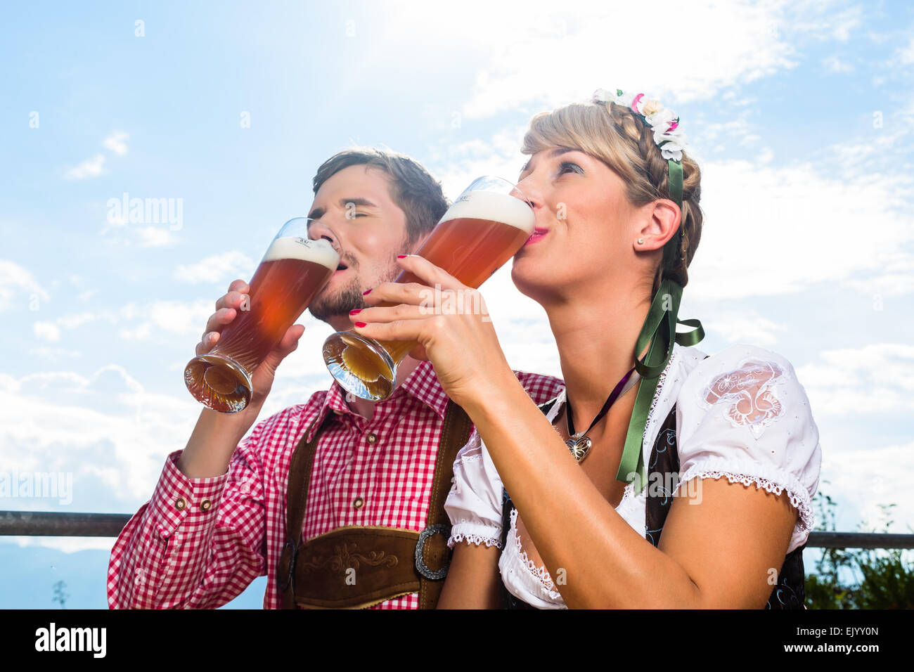 Couple on mountain hut in the Alps drinking wheat beer Stock Photo - Alamy
