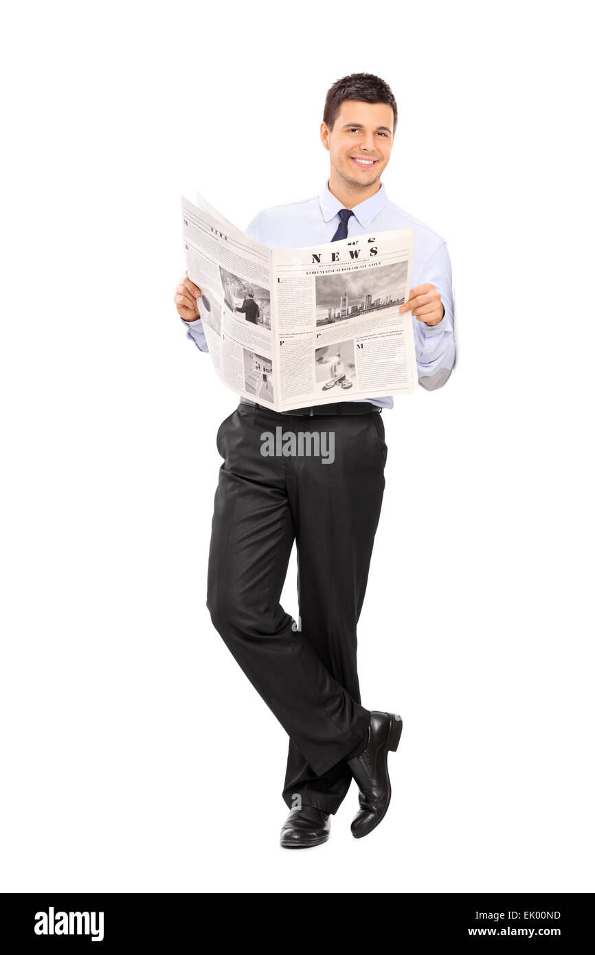 Full length portrait of a handsome man holding a newspaper and leaning ...