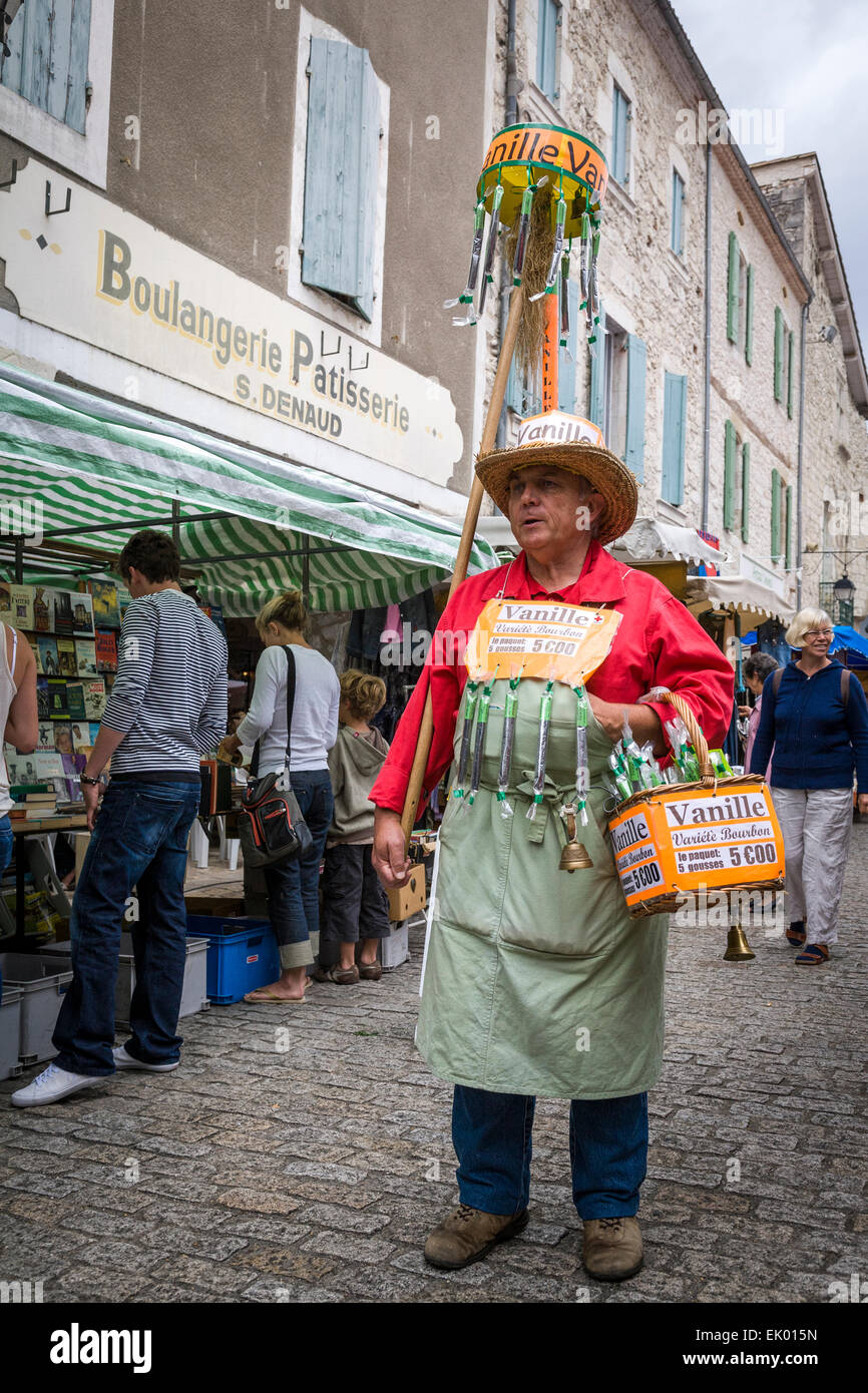 A vanilla pod salesman sings his way around the market square, Eymet ...