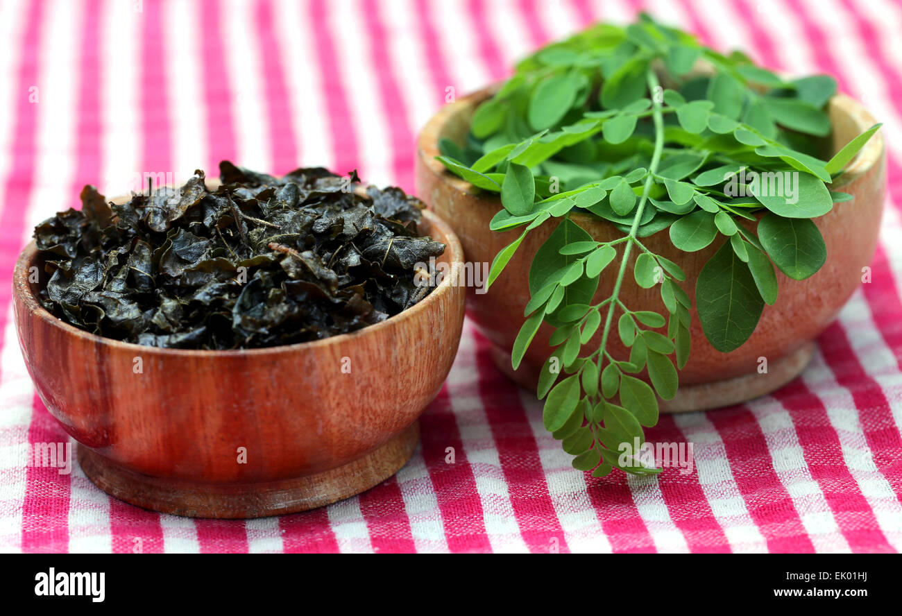 Fried and green moringa leaves in wooden bowls Stock Photo - Alamy