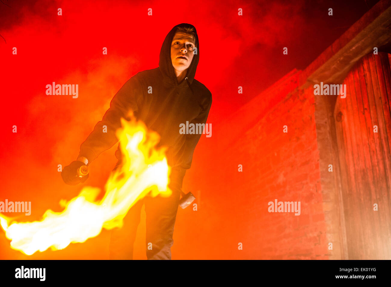 Urban rioter at night - a angry young teenage man boy wearing a black ...