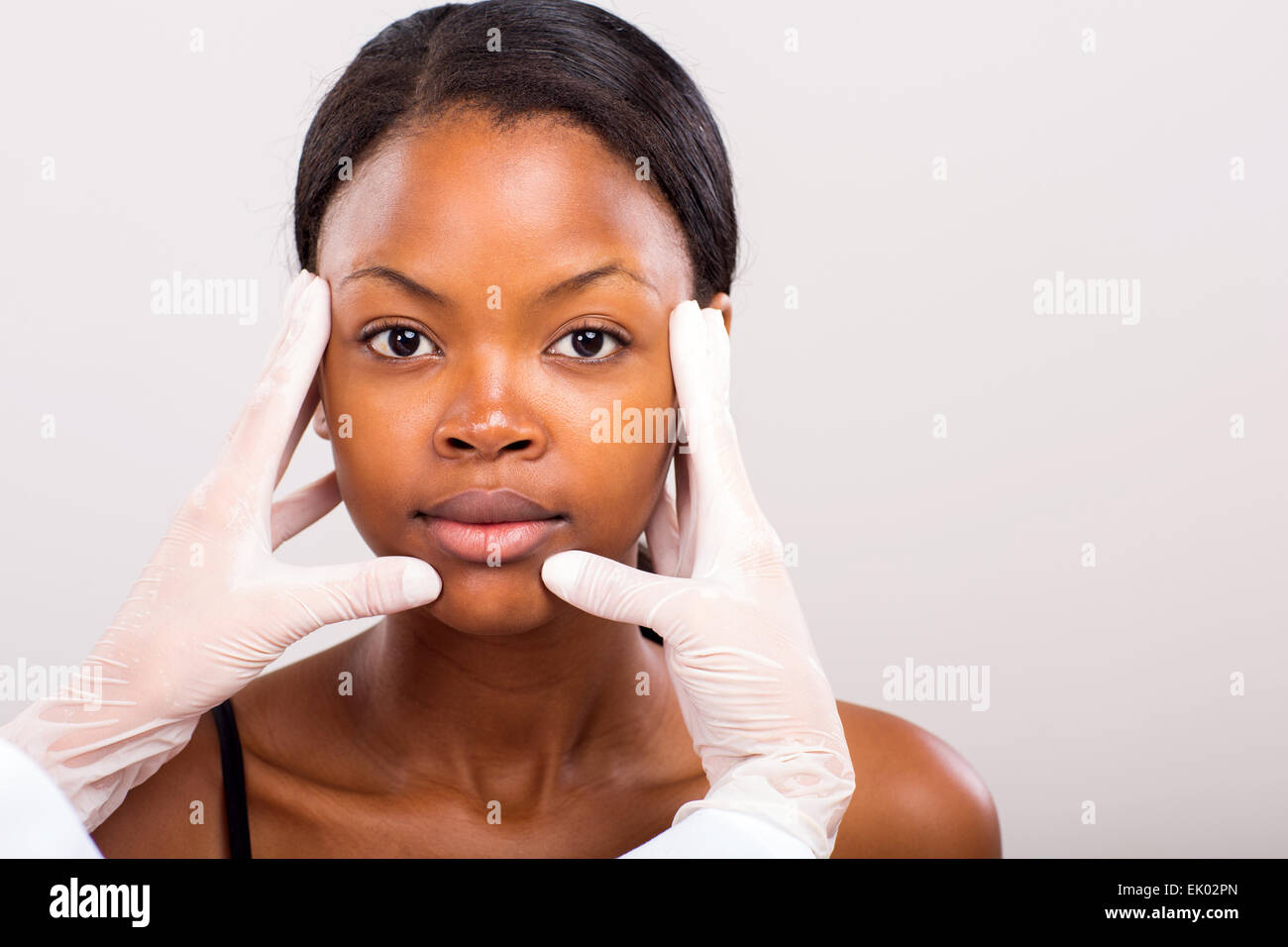 doctor doing skin check on African woman before cosmetic surgery Stock ...