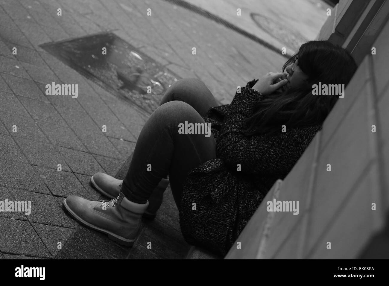 Girl sitting, waiting for someone on the street Stock Photo - Alamy