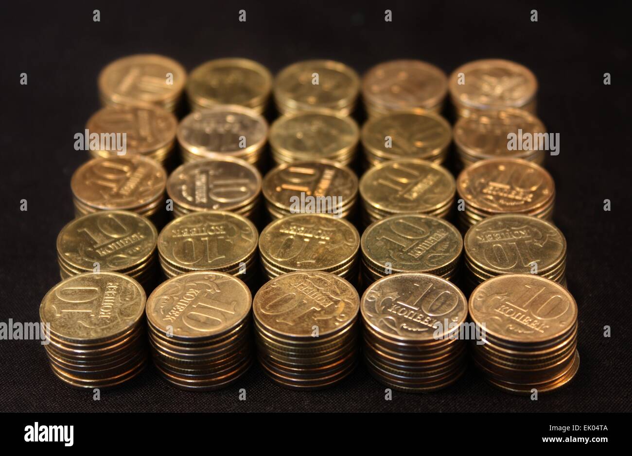 Coins stacked on a black background Stock Photo - Alamy