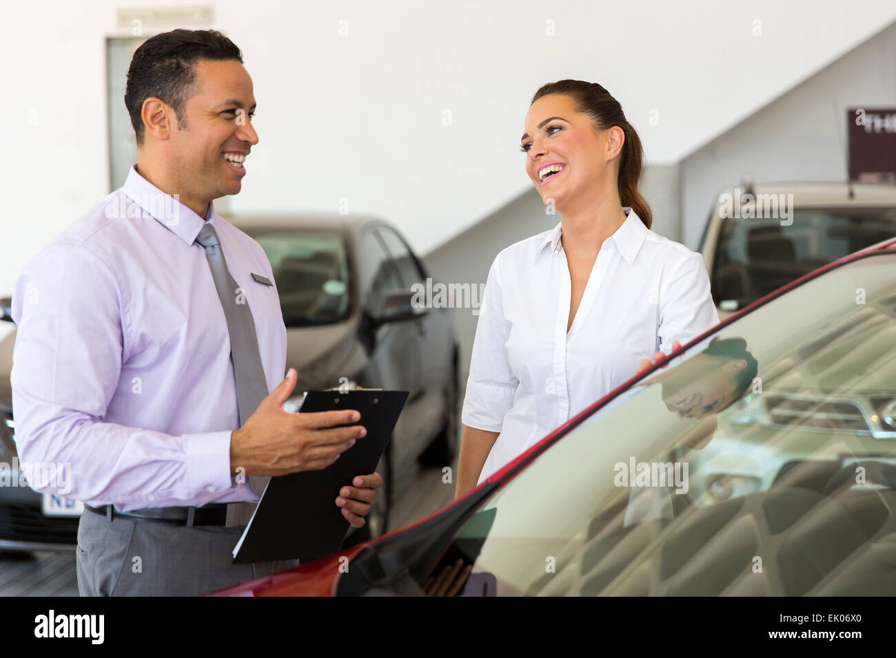middle aged car salesman talking to a customer in showroom Stock Photo ...