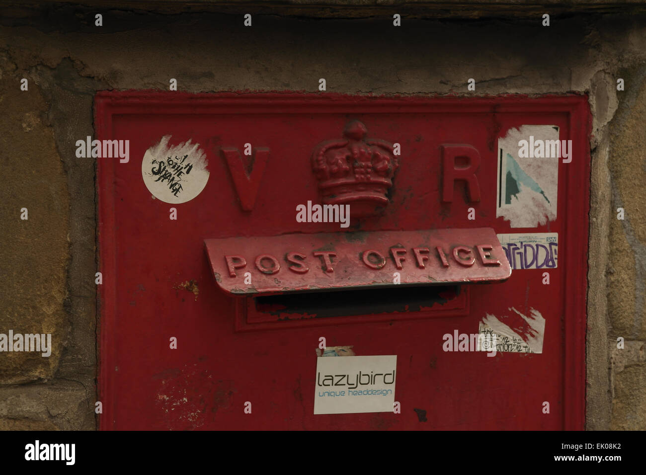 Close-up Victorian postbox, with stickers, inset stone wall Portico ...