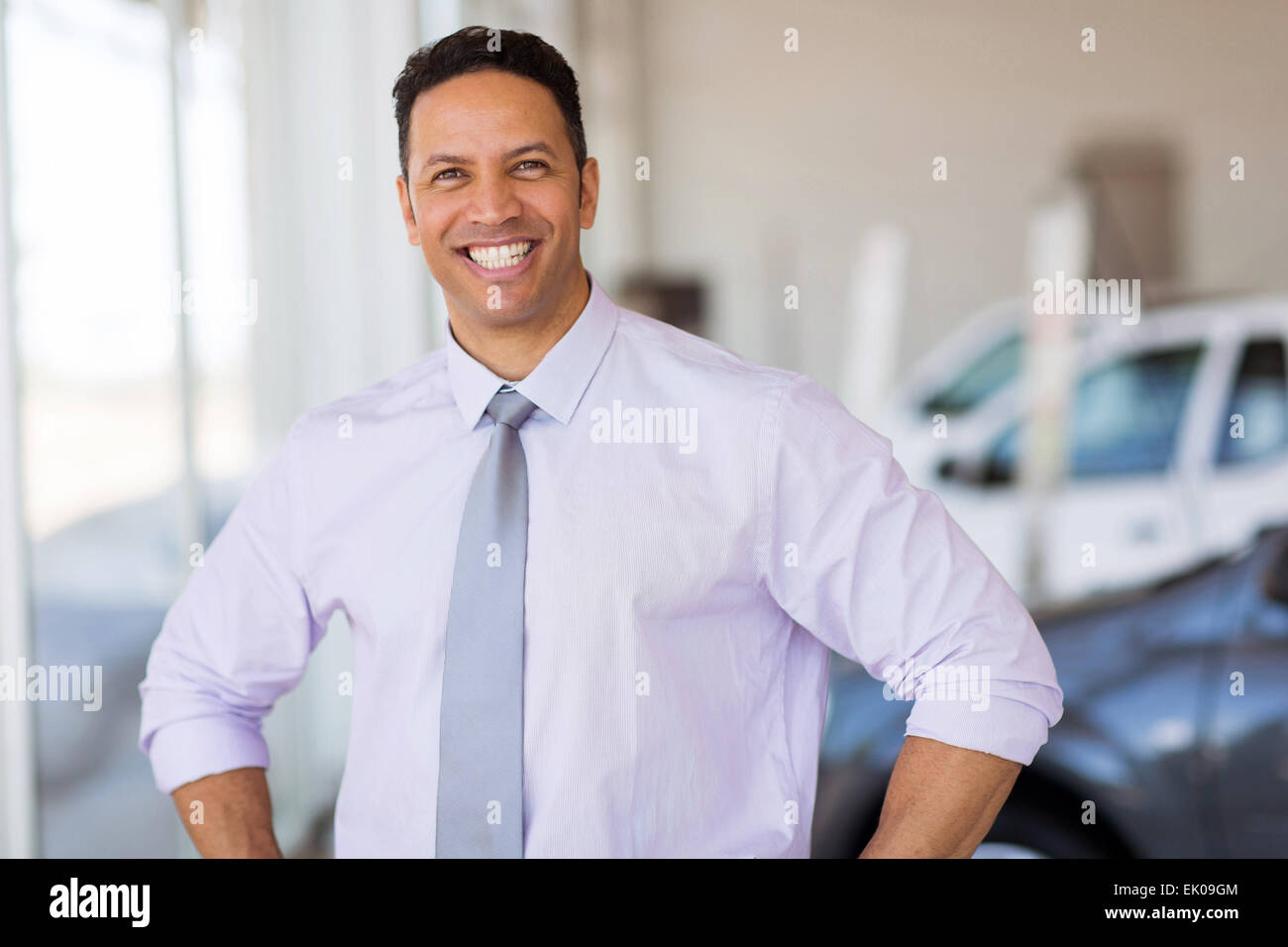 happy middle aged salesman standing at car dealership Stock Photo - Alamy