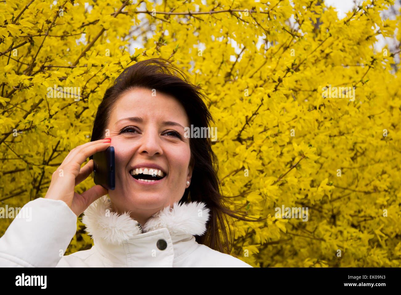 Pretty young woman smiling while talking on the phone.She is smiling as ...