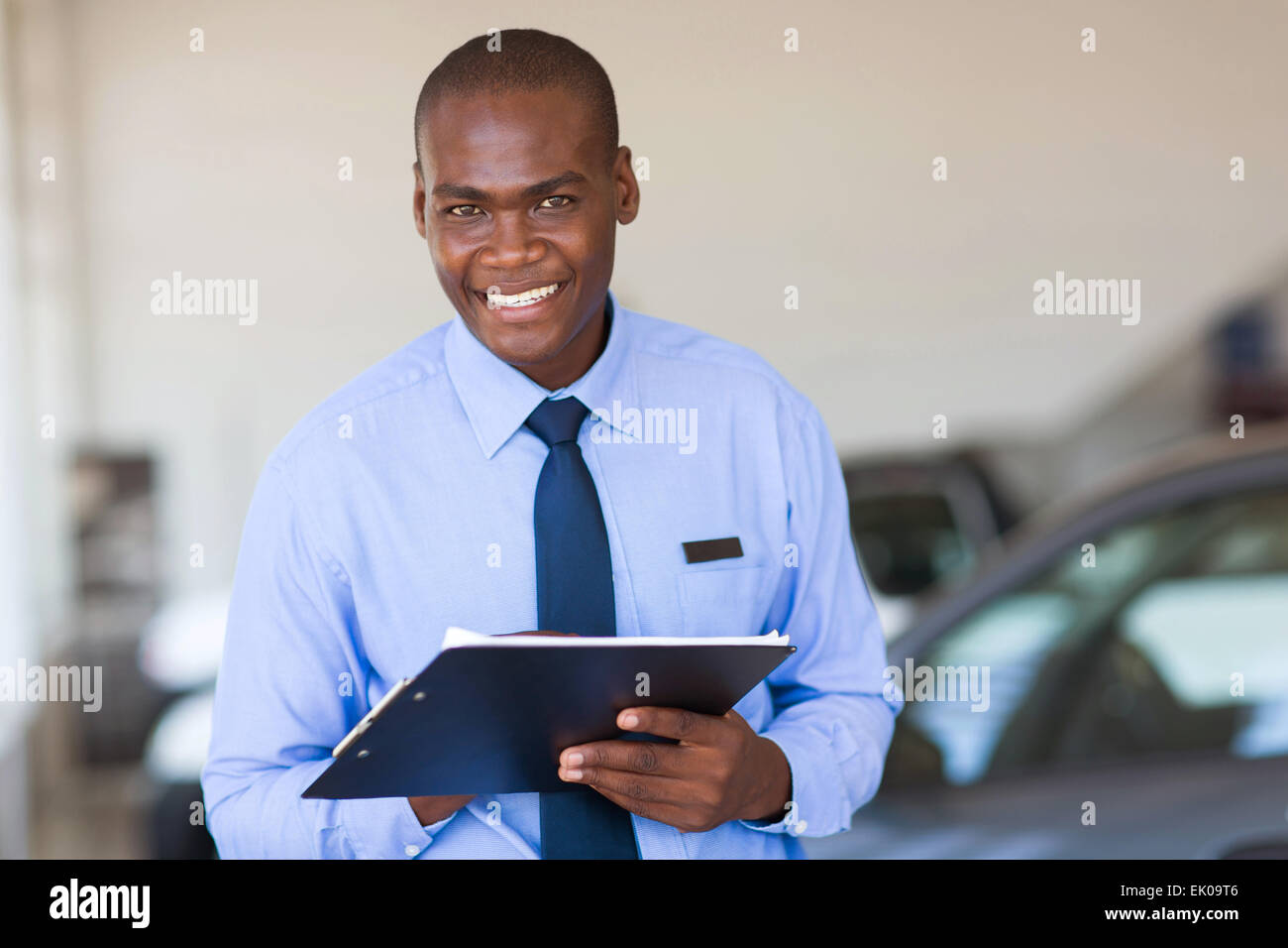 handsome African salesman working at vehicle showroom Stock Photo - Alamy