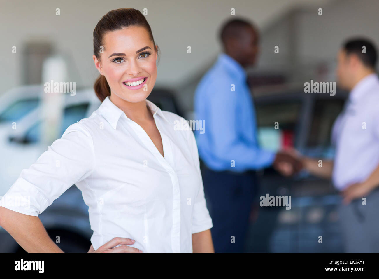 pretty female car dealer inside showroom Stock Photo - Alamy