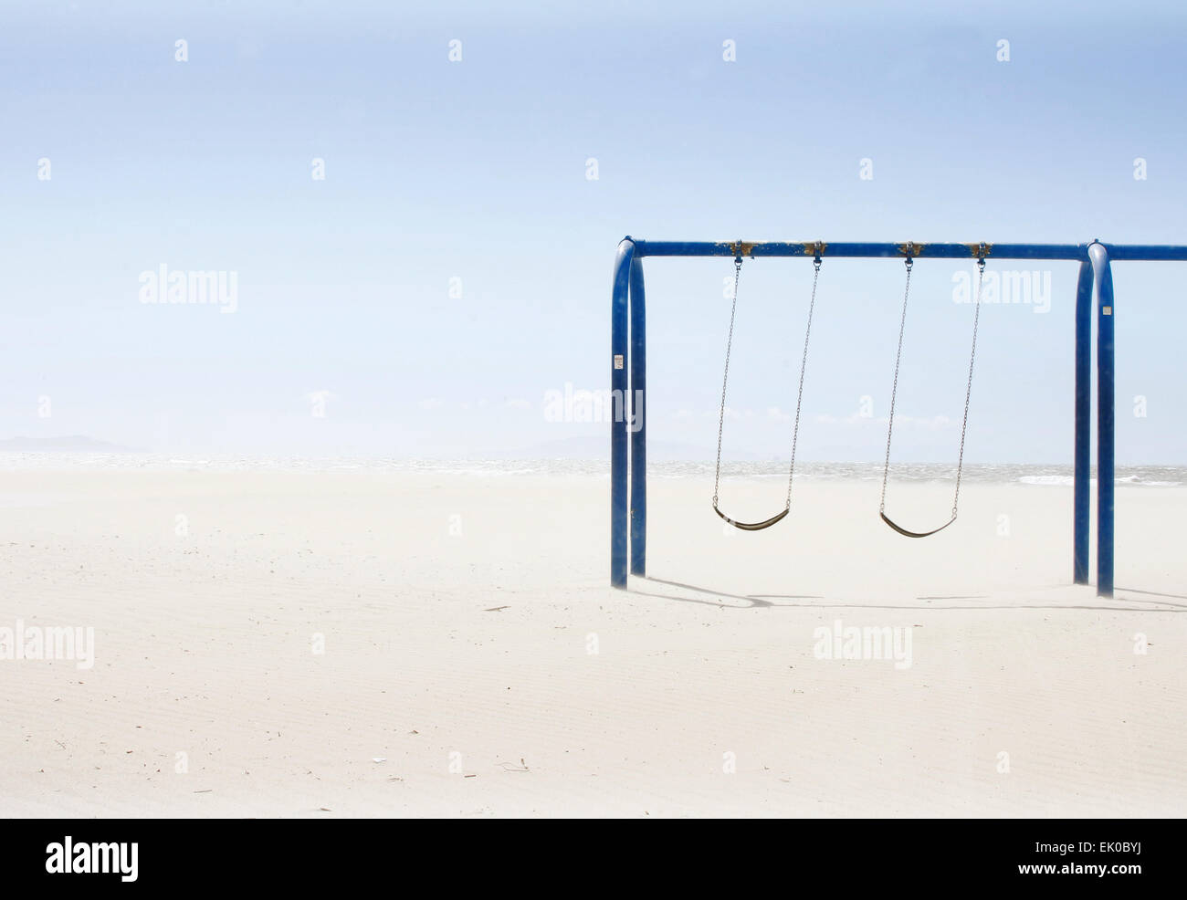 Swaying swing set in the breeze on the beach Stock Photo - Alamy