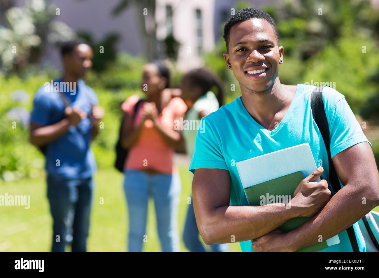 happy male African college student holding books Stock Photo - Alamy
