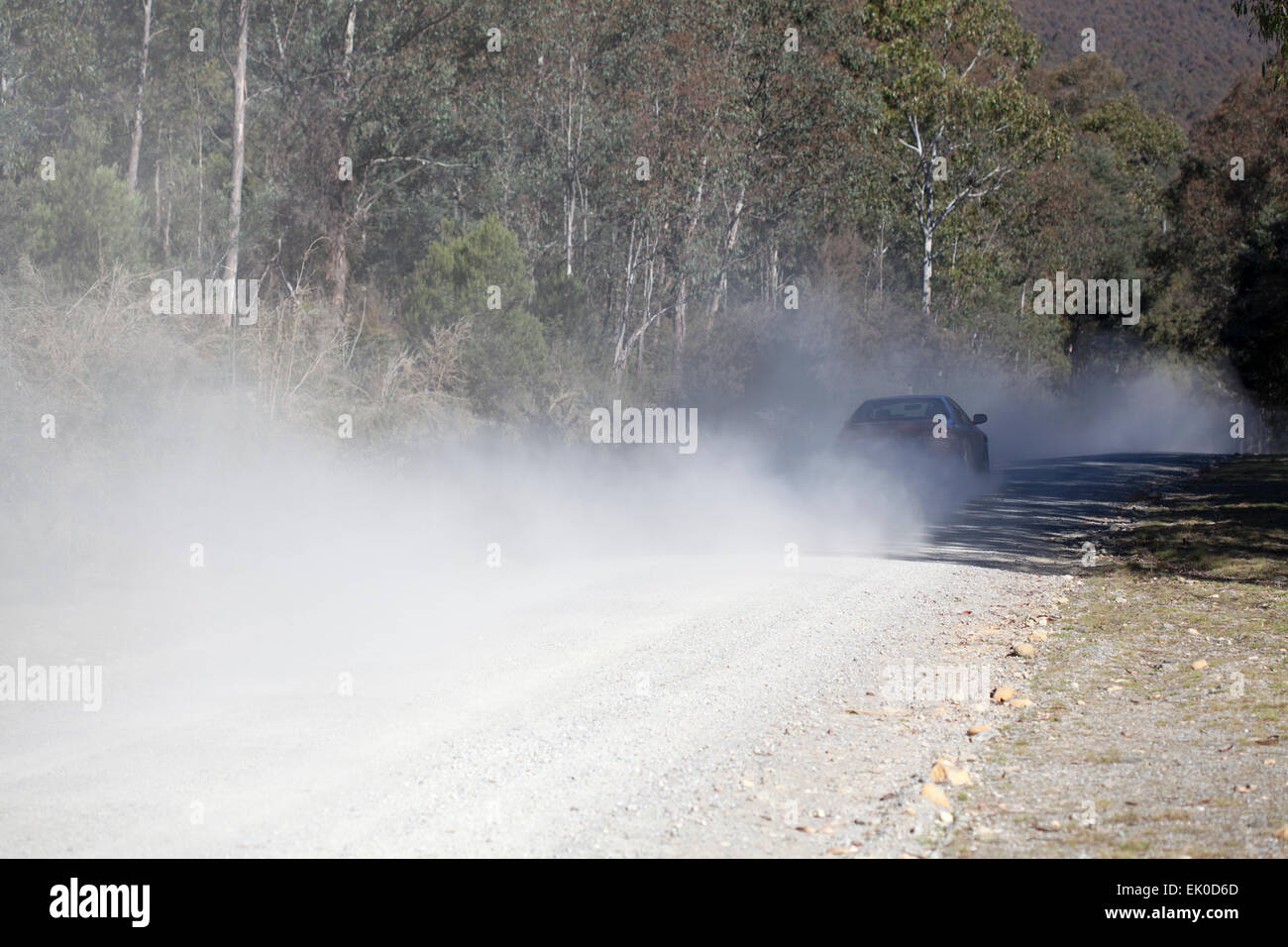 A car drives very fast up a dirt road in the mountains on Tasmania ...