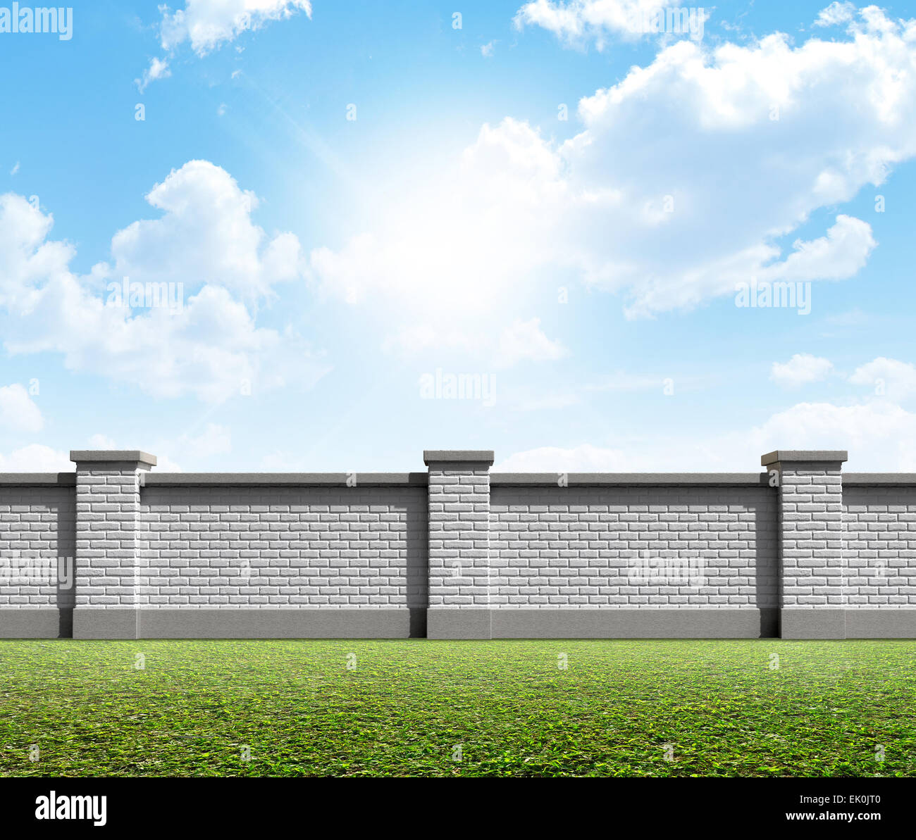 An front view of a regular domestic brick wall on a green grass and ...