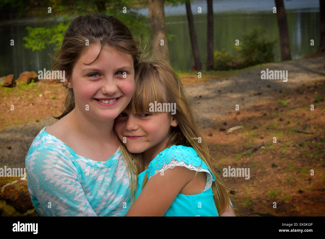 Two sisters hug at a park Stock Photo - Alamy