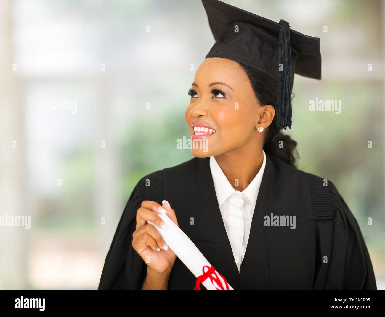 beautiful young African college graduate looking up Stock Photo - Alamy