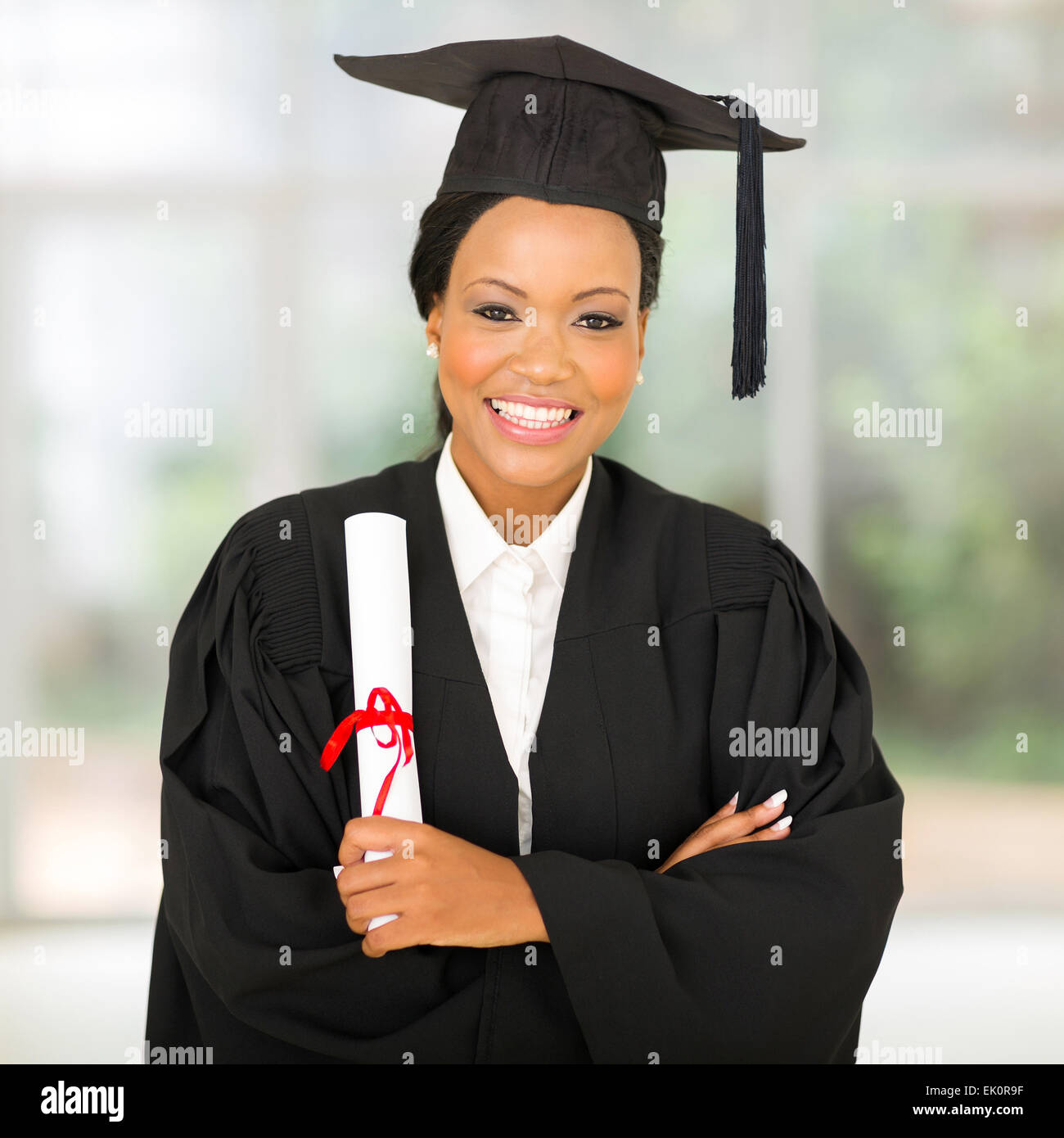 beautiful female African graduate with arms crossed Stock Photo - Alamy