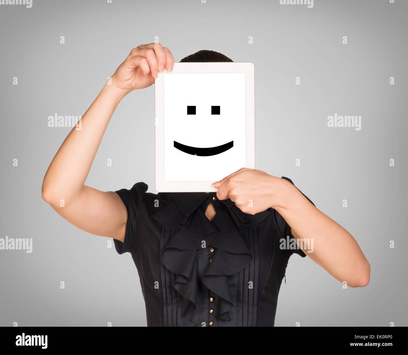 Girl in black dress covered her face with tablet. On screen code smiley ...