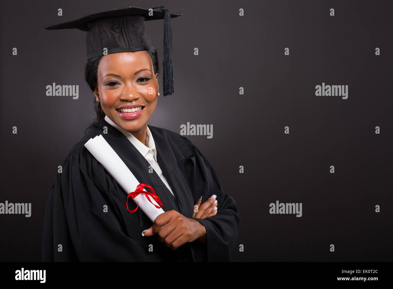 portrait of beautiful young African American graduate holding diploma ...