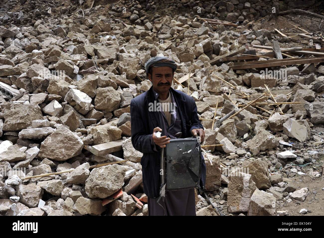 Sanaa, Yemen. 4th Apr, 2015. A Yemeni man stands on the rubbles of his ...