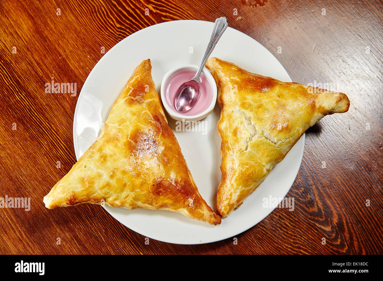 Uzbek national dish samosa, two pieces lie on a white plate, vinegar ...