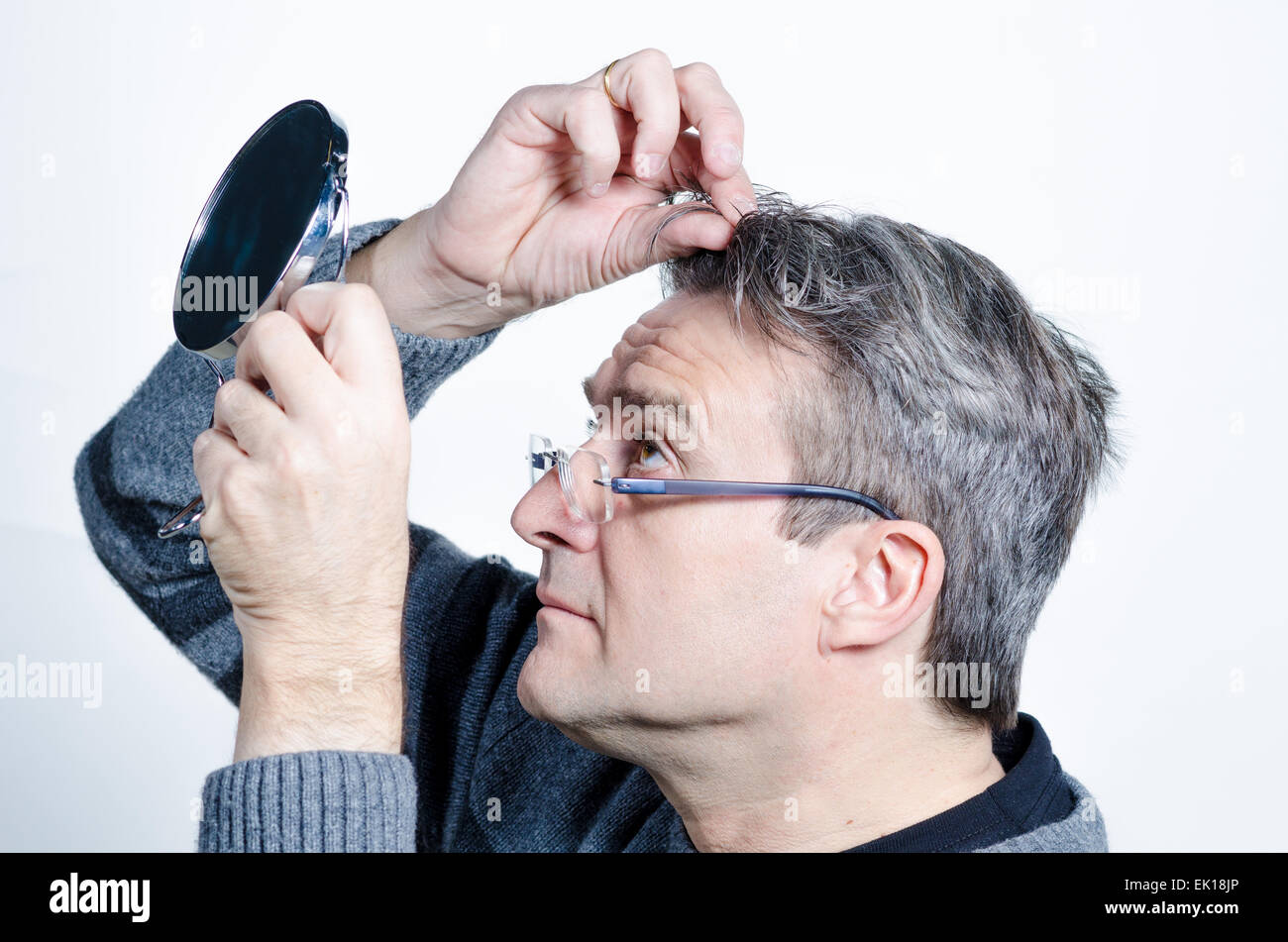 Guy checking out his hair with a mirror Stock Photo - Alamy