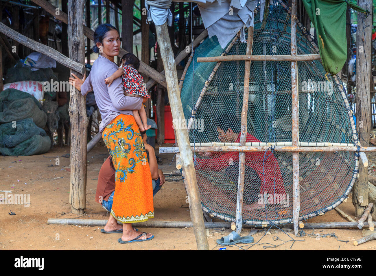 A fisherman adjusts his net at Kampong Phulk floating village Stock ...